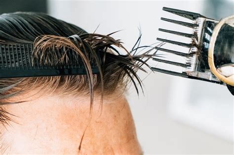 Premium Photo Barber Cutting Mans Hair Using Electric Razor