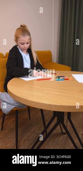 Concentrated Elementary School Student Draws A Picture With Colored