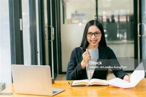 집에서 노트북과 종이 문서를 읽고 일하는 자신감 있는 아시아 여성 양복을 입은 쾌활한 여성이 사무실책상에 앉아 있다 가상현실에 대한 스톡 사진 및 기타 이미지 Istock