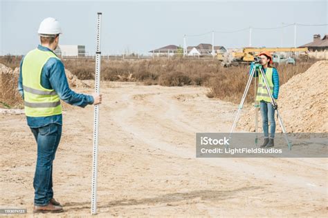비포장 도로에서 작업하는 디지털 레벨 및 측량 통치자를 가진 측량사 기포수준기에 대한 스톡 사진 및 기타 이미지 기포수준기 삼각대 2명 Istock