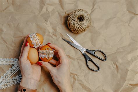 레이스와 밧줄로 크래프트 종이에 부활절 달걀을 장식합니다 구겨진 크래프트 종이 배경에 세 부활절 달걀 여자는 손에 계란을 들고 4월에 대한 스톡 사진 및 기타 이미지