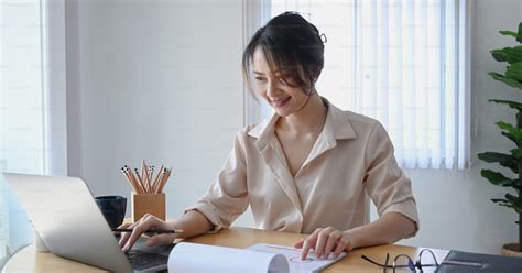 웃는 사업가는 컴퓨터 노트북을 사용하고 사무실 책상에서 재무 보고서를 분석합니다 사진 Unsplash의 테이블 이미지