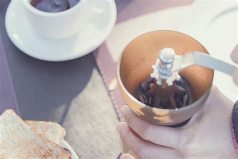 자연 녹색 배경이 차가운 느낌과 자연에서 휴식을 취하기위한 테이블에 커피 콩을 분쇄하기위한 수동 분쇄기 커피에 클로즈업 탑뷰 손 구이에 대한 스톡 사진 및 기타 이미지