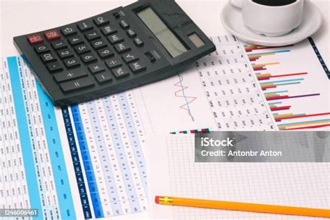 회사의 재무 지표 계산기 커피 한 잔 공간 사본이 있는 메모장이 있는 테이블입니다 기업의 수입과 수입 회계사 분석가의 사무실