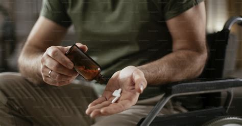 휠체어를 탄 슬픈 불행한 우울한 남자가 손에 알약을 들고 있다 한 줌의 알약을 들고 있는 남자를 닫습니다 사진 Unsplash의 세르비아 이미지