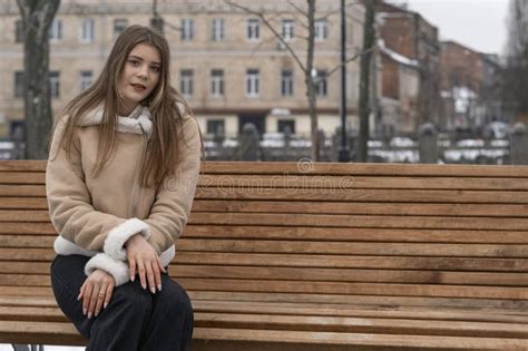 Beautiful Young Girl Sitting On A Bench In The City Winter Time Stock