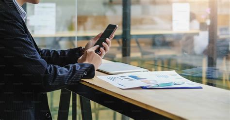 문서와 함께 휴대 전화를 사용하는 사업가는 테이블에 정보를 그래프로 표시합니다 사진 Unsplash의 사업 이미지