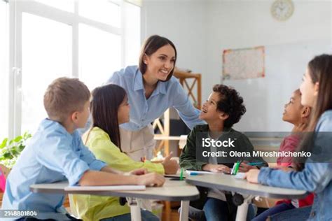 교실 책상에 앉아 선생님과 이야기하는 모습 수업 시간에 공부하는 모습 학생들에게 과목을 설명하는 여성 등 다양한 아이들이 행복하다 교사 교육 관련 직업에 대한 스톡 사진 및