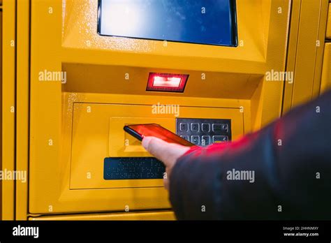 Detail Of The Arm Of A Man Scanning A Code On The Mobile Phone To Pick Up A Package From The
