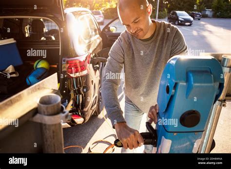 Mature Man Plugging Cable At Electric Station Stock Photo Alamy