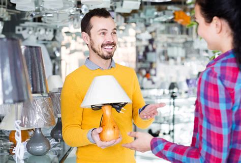 남자와 여자 집 인테리어에 대 한 세련 되 고 현대적인 램프를 선택 하는 라이터가 게에서 18 19세에 대한 스톡 사진 및 기타 이미지 18 19세 가격 고급