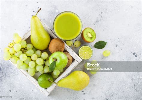 돌 부엌 배경에 흰색 빈티지 상자에 유기 녹색 톤 과일과 신선한 스무디의 유리 키위와 라임과 사과와 배와 포도 맨 위 보기 0