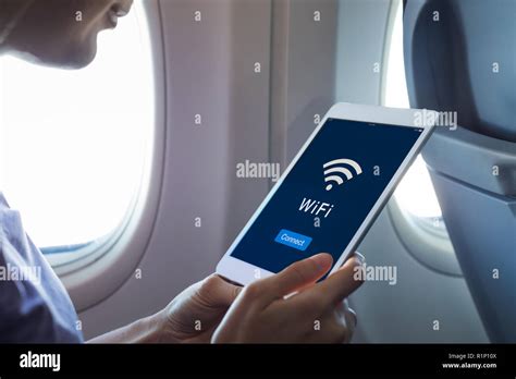Wifi Internet Access In Airplane During Flight Passenger Using Tablet Computer To Connect To
