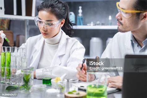 과학 실험실에서 유기농 자연 허브 식물과 의학 화학 연구 유리 제품에 화장품 추출물 액체 화학 오일 미용 의료 케어 혈청 제품 실험의 잎 생물학 2명에 대한 스톡 사진 및