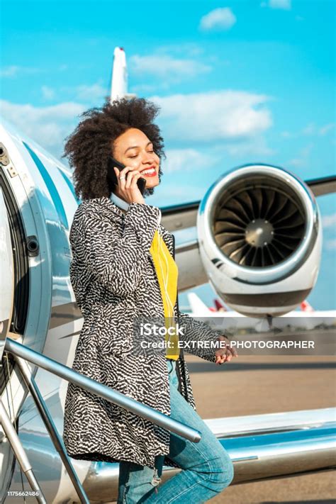 공항 활주로에 주차 된 개인 비행기에서 나오는 스마트 폰에 말하는 젊은 부자 여성 개인 비행기에 대한 스톡 사진 및 기타 이미지 개인 비행기 곱슬 머리 공항 Istock