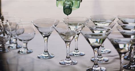 웨이터가 결혼식 피로연에서 테이블 파티에 크리스탈 안경에 마티니를 붓는다 마티니 행은 알코올 바에서 음료를 마신다 크리스마스와 새해 축제 축하와 파티 개념입니다 사진