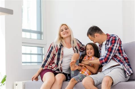 Sonriendo Padres Jóvenes Y Sus Hijos Están Muy Felices Están En Casa Foto Premium