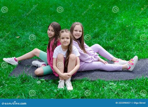 Three Beautiful Happy Tween Teenagers Girls In Colorful Clothes Sitting