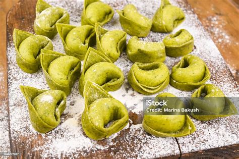 토르텔리니 E 토르텔로니 전형적인 요리 에밀리아 이탈리아 수제 생 이탈리아 어 토르텔로니와 나무 배경에 녹색 페스토 재료와 음식 배경 높은 각도 보기 공간을 복사합니다 0