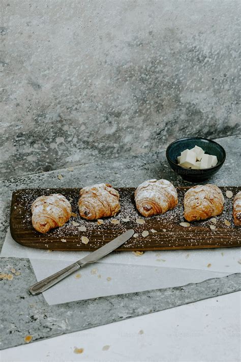 버터 한 그릇 옆에 페이스트리를 얹은 나무 쟁반 사진 Unsplash의 베이커리 제품 이미지