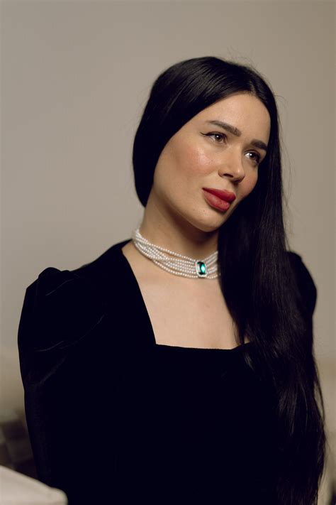 진주 목걸이를 한 하얀 드레스를 입은 우아한 여성 · 무료 스톡 사진