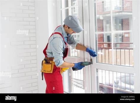 Man Fixing Lock To Window With Electric Screwdriver Stock Photo Alamy
