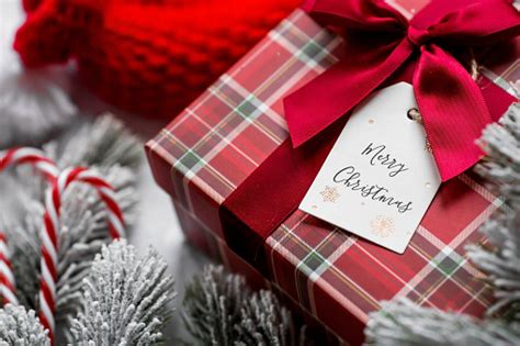 빨간 선물 상자 가문비 나무 가지 사탕 지팡이 및 회색 대리석 배경에 메리 크리스마스라는 글자가있는 레이블 크리스마스 휴일 2023 가족 및 친척을위한 선물 구매 및 준비