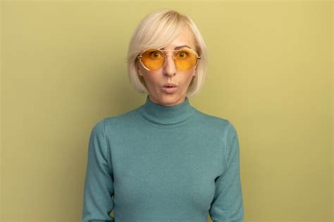 Возбужденная красивая блондинка славянская женщина в солнцезащитных очках выглядит изолированной