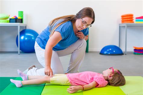 물리 치료 세션에서 신체 장애가 있는 어린이 뇌성마비를 앓고 있는 아이가 물리치료 중 치료사와 함께 운동하는 모습 뇌성 마비에 대한 스톡 사진 및 기타 이미지 Istock