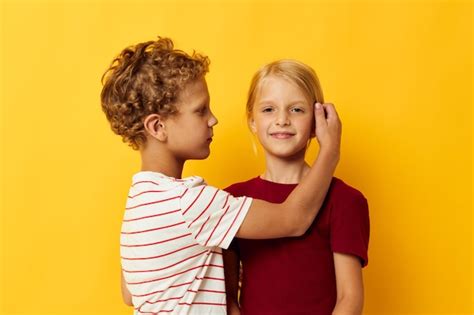 Hermoso Hermano Abrazando A Su Hermana Contra Un Fondo Amarillo Foto Premium