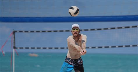 한 남자가 해변에서 배구를 하고 있습니다 사진 Unsplash의 실외 배구 이미지