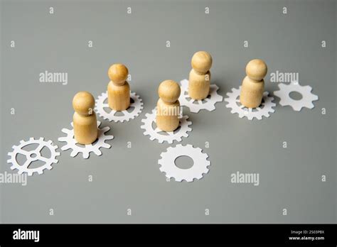 A Conceptual Image With Wooden Figures Standing On Interconnected Gears Teamwork Collaboration