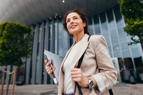 노트북과 안경을 들고 사무실 건물 밖을 걷고 있는 웃는 사업가 40 49세에 대한 스톡 사진 및 기타 이미지 40 49세 강철 개인 장식품 Istock