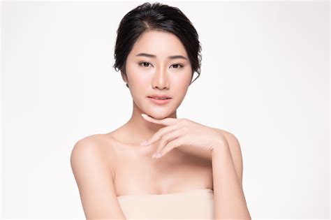 깨끗 하고 신선한 피부와 함께 부드러운 뺨과 미소를 만지는 아름 다운 젊은 아시아 여자 행복과 쾌활한 흰색 배경에 고립 아름다움과 화장품 개념 건강관리와 의술에 대한 스톡