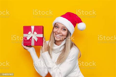 흰색 따뜻한 스웨터와 빨간 산타 모자를 쓴 한 젊은 여성이 선물 상자를 보여줍니다 크리스마스와 새해 컨셉 30 34세에 대한 스톡 사진 및 기타 이미지 Istock