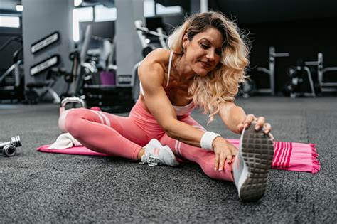 체육관에서 운동하기 전에 스트레칭하는 젊은 근육질 여성 건강한 생활방식에 대한 스톡 사진 및 기타 이미지 건강한 생활방식 스포츠 강사 Istock