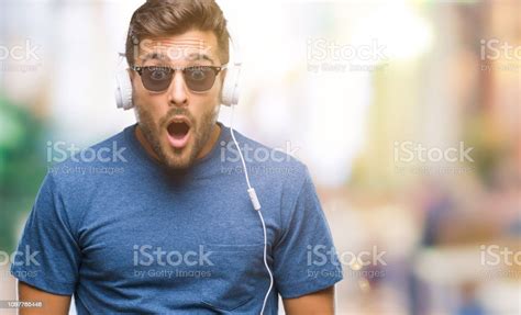잘생긴 젊은이 두려워 하 고 놀라운 식 공포와 흥분된 얼굴 충격 절연 배경에 음악을 듣고 하는 헤드폰을 착용 감정에 대한 스톡