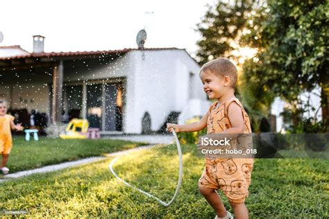 정원 호스로 재미있게 놀고있는 어린 소년 뒷마당에 물을주는 어린 소년 놀기에 대한 스톡 사진 및 기타 이미지 놀기 놀이 아이 Istock