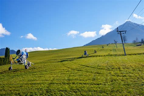 오스트리아 티롤의 Walchsee 스키 리조트에서 스키 슬로프를 준비하기 위해 사용을 기다리고 있는 스노우 캐논 줄 표면 리프트 건설을 위한 컨베이어 케이블 및 지지대 0