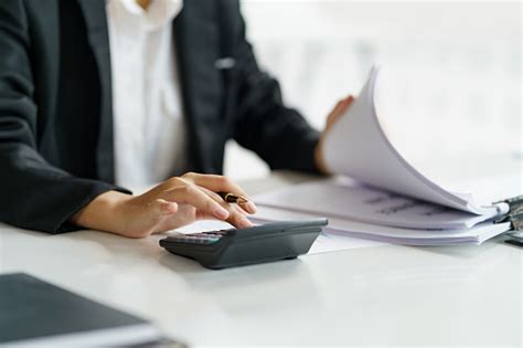 계산기를 사용하여 회사 재정과 수입 및 예산을 확인하기 위해 비즈니스 여성 손의 클로즈업 거래 내역서에 대한 스톡 사진 및 기타 이미지 거래 내역서 검사 보기 경제