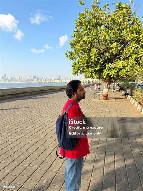 마린 드라이브 C 자형 산책로 뭄바이 인도 인도의 국기로 그려진 나무 줄기의 거리 콘크리트 방파제 방어 벤치 해안 관리 고층 빌딩 맑은 푸른 흐린 하늘 전경에 초점을 맞춘