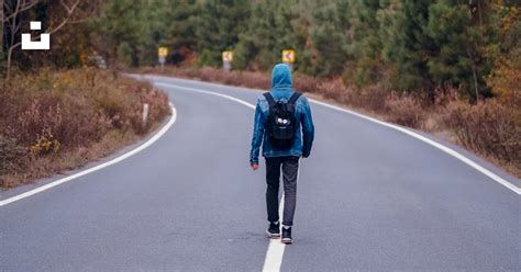 파란 재킷을 입은 사람이 길을 따라 스케이트보드를 타고 있다 사진 Unsplash의 무료 가방 이미지