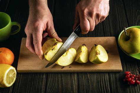 집에서 사과 설탕에 절인 과일 또는 과일 음료를 만듭니다 커팅 보드에 신선한 사과를 자르는 칼을 든 요리사의 손 사과에 대한 스톡 사진 및 기타 이미지 Istock