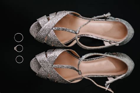 실버 신발과 반지 검은 배경에 고립 된 구성 액세서리 신부 신발 웨딩 링과 샌들 크리스탈 신발 닫아 플랫 레이 맨 위 보기 약혼