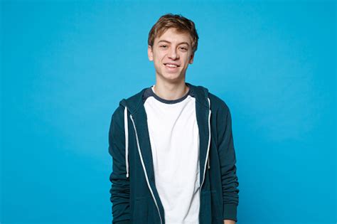 스튜디오에서 파란색 벽 배경에 고립 된 서 캐주얼 복장에 웃는 잘생긴 젊은 남자의 초상화 사람들은 진심으로 감정 라이프 스타일 개념입니다 복사 공간을 모의 합니다 광고 영역