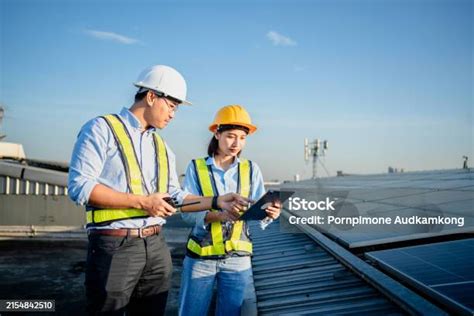 함께 일하는 두 명의 전기 엔지니어는 디지털 태블릿을 사용하여 태양광 발전소 재생 에너지 지속 가능한 비즈니스 개념에 태양 전지판의 설치 및 유지 관리를 검사합니다 25