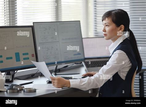 Side View Portrait Of Asian Woman As Female Engineer Using Computer