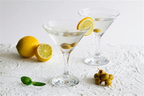 알코올 음료 바에서 마가리타 칵테일 흰색 배경에 녹색 민트와 올리브 칵테일의 두 마티니 안경 테이블에 올리브마티니 안경 복사 공간을 복사합니다 0명에 대한 스톡 사진 및