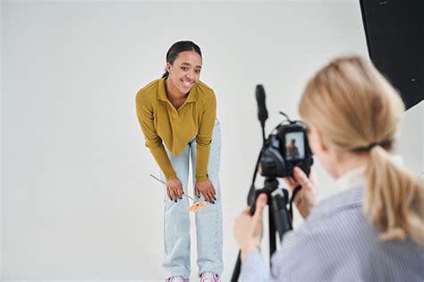 카메라를 들고 스튜디오에 서있는 동안 백인 사진작가가 그녀의 다민족 모델을 촬영 사진작가에 대한 스톡 사진 및 기타 이미지 사진작가 패션모델 18 19세 Istock