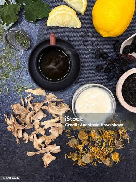 면역을위한 차 감기 치료를위한 성분 따뜻한 한방 약 음료 말린 금송화 꽃 말린 생강 장미 엉덩이 꿀 레몬을 검은 돌 표면에 얹어 보입니다 0명에 대한 스톡 사진 및 기타